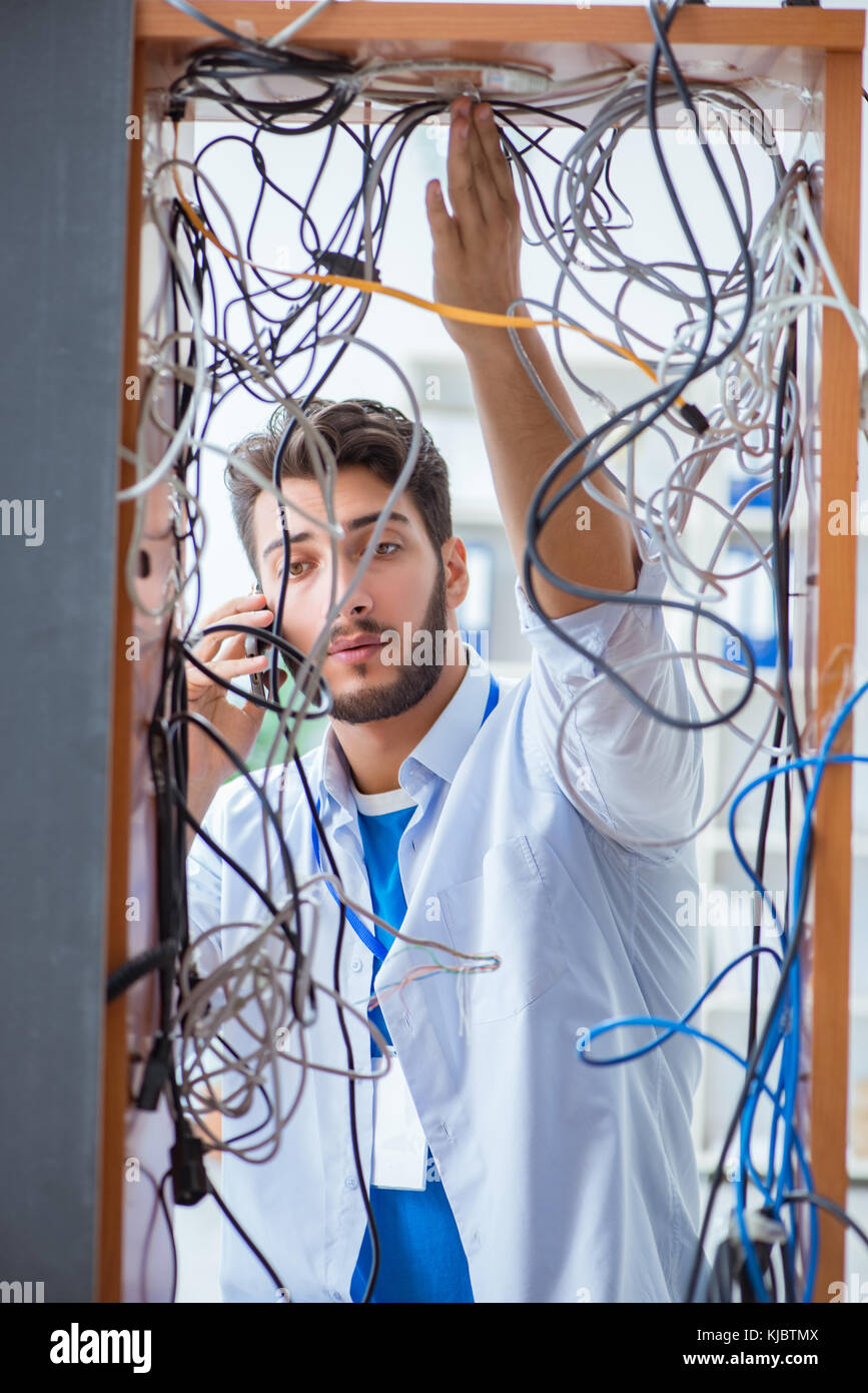 Electrician trying to untangle wires in repair concept Stock Photo - Alamy