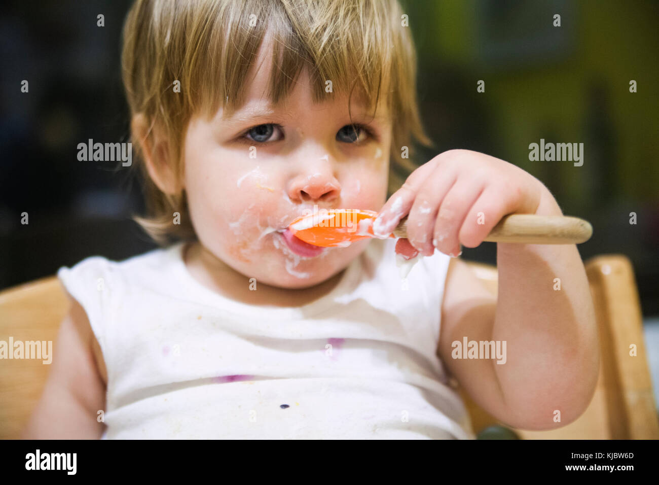 Messy child eating with a spoon Stock Photo - Alamy