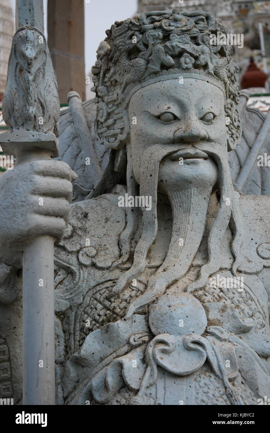 A stone statue of a Chinese guardian at the entrance of Wat Arun ...