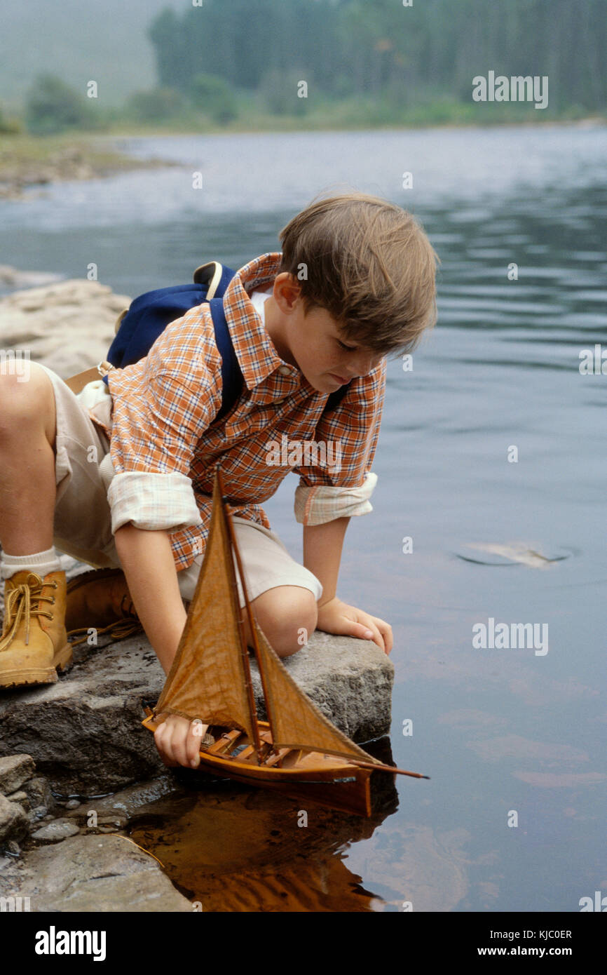 Boy Playing with Boat in Lake Stock Photo - Alamy