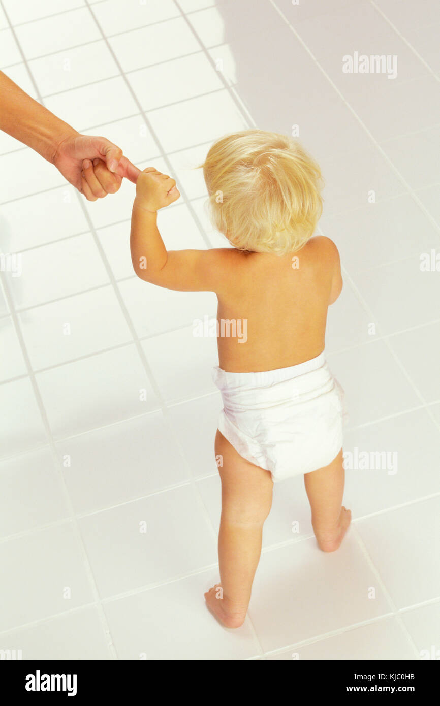 Parent Helping Baby to Walk Stock Photo - Alamy