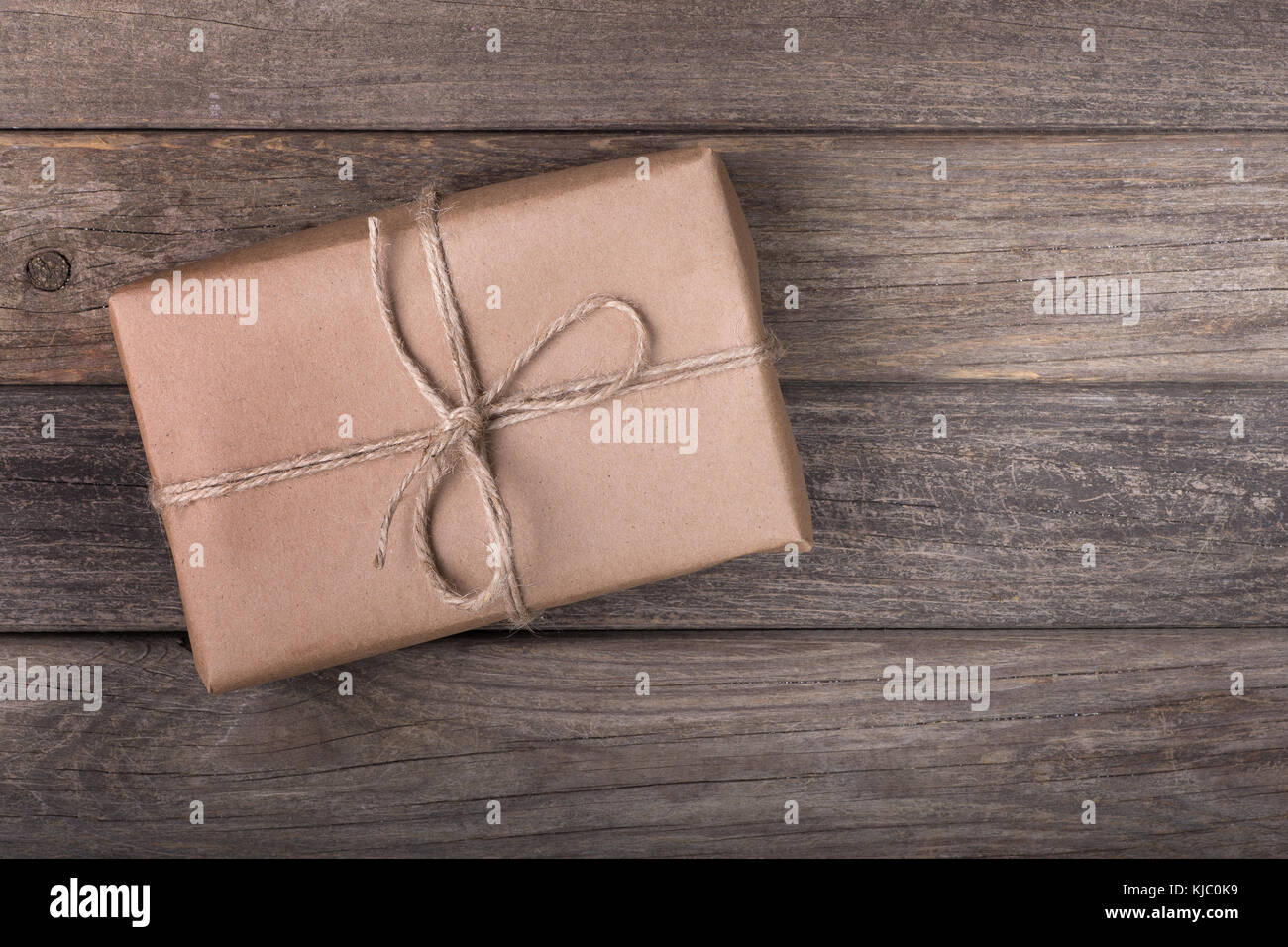 Single brown package tied with string on a wood background Stock Photo ...