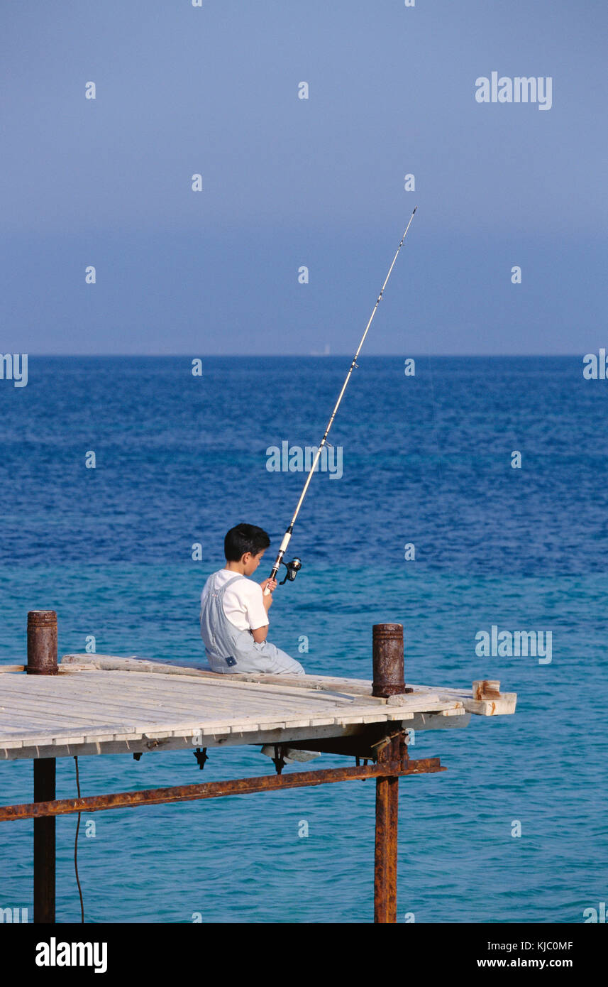Boy Sitting on Dock Stock Photo - Alamy