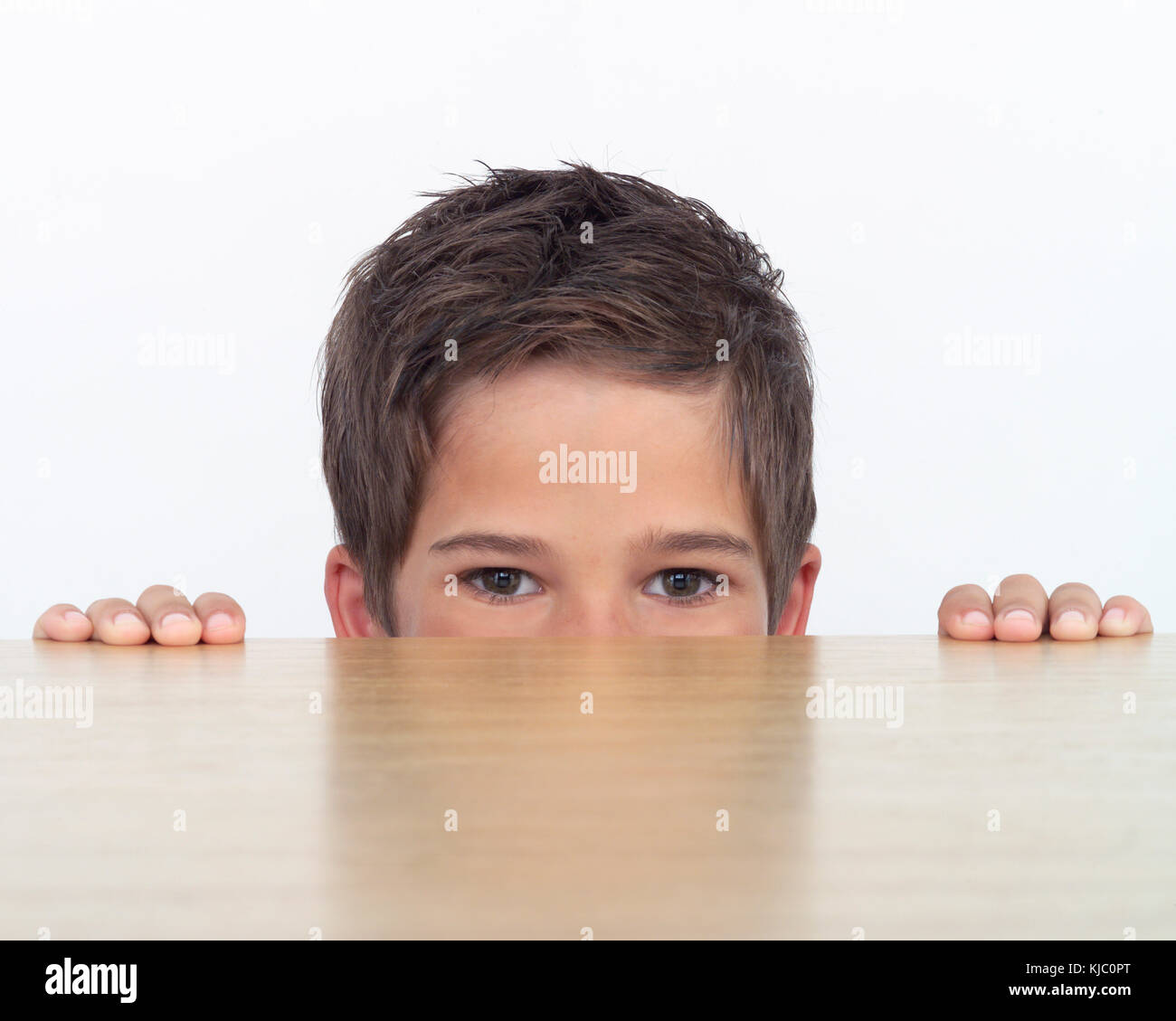 Boy Peeking over Wooden Table Stock Photo - Alamy