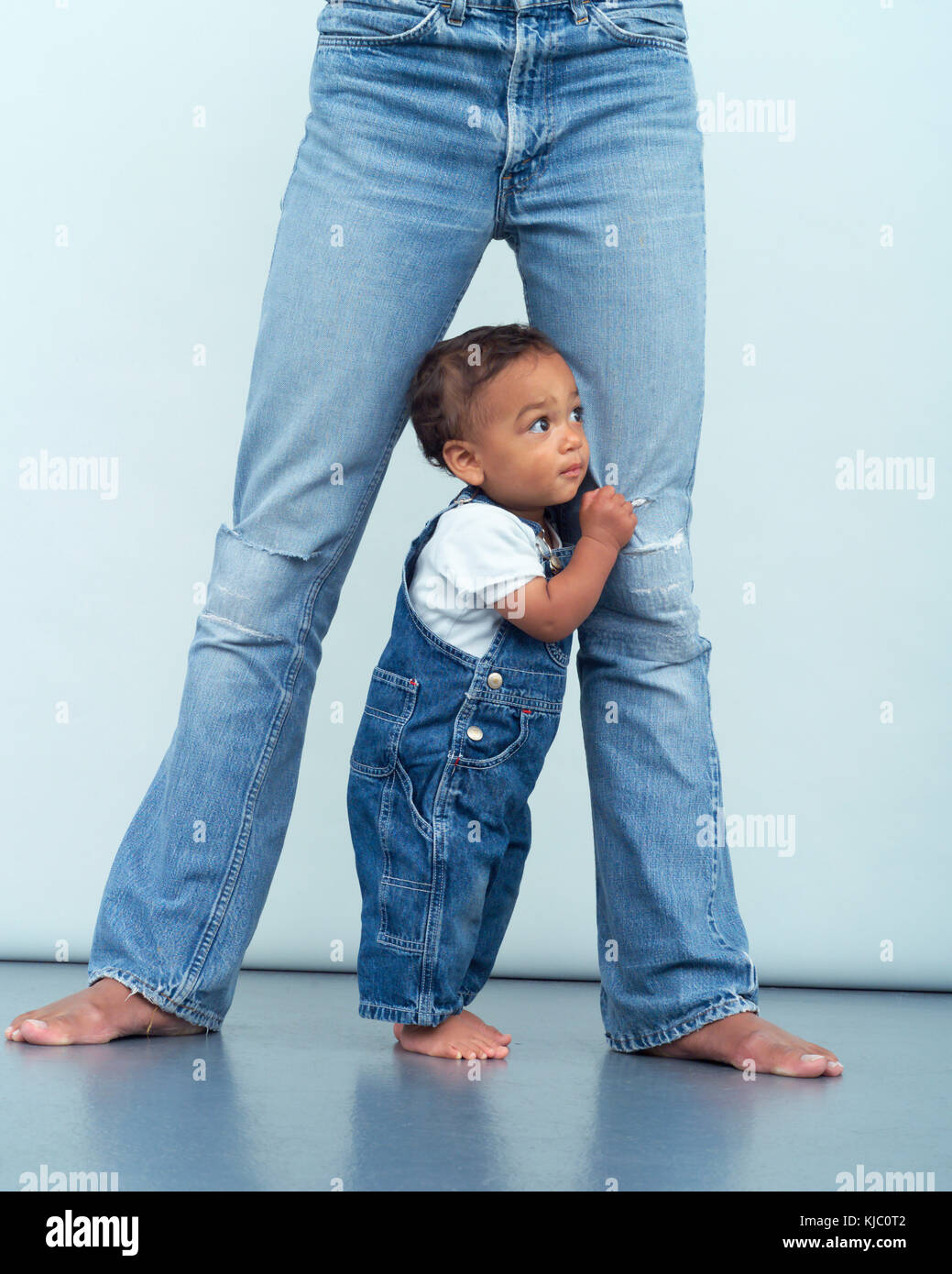 Baby Holding on to Mother's Legs Stock Photo - Alamy