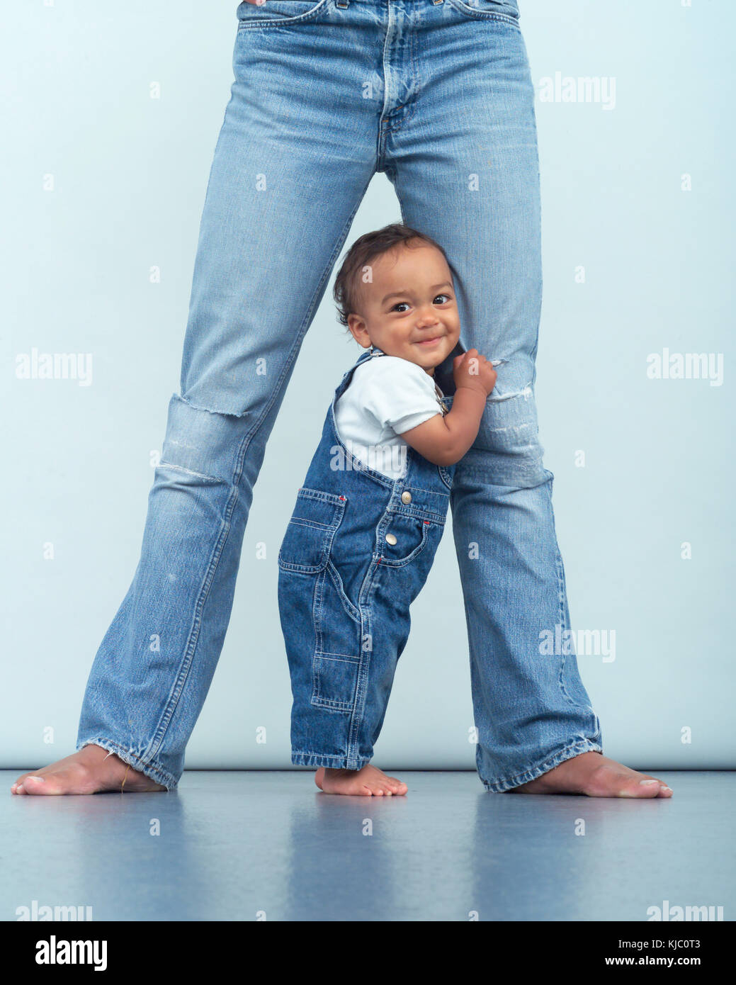 Baby Holding on to Mother's Legs Stock Photo - Alamy