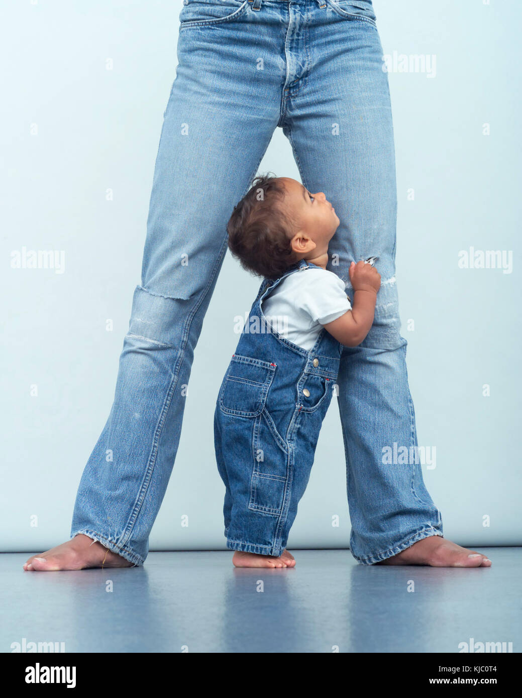 Baby Holding on to Mother's Legs Stock Photo - Alamy