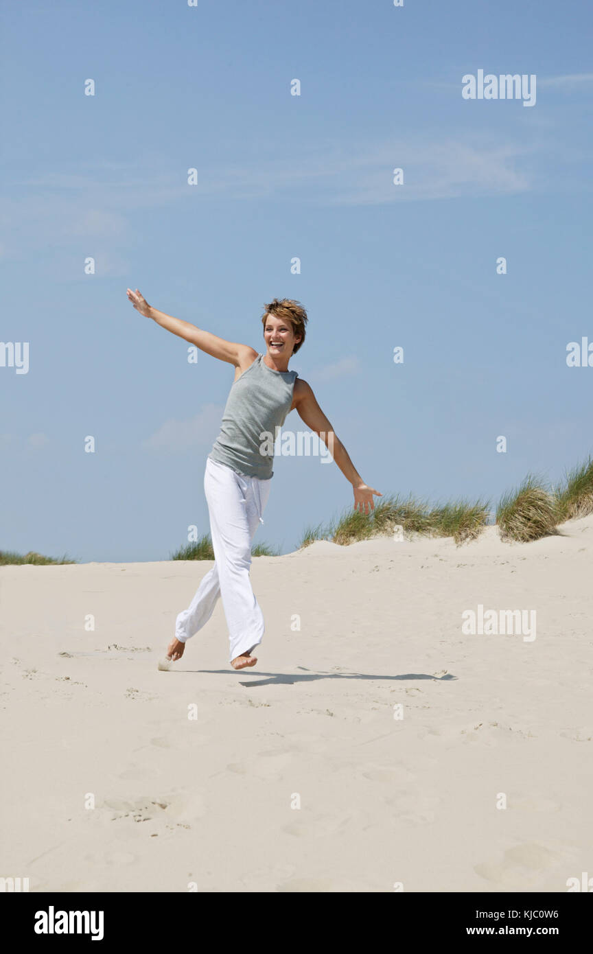 Woman Running over Sand Stock Photo - Alamy