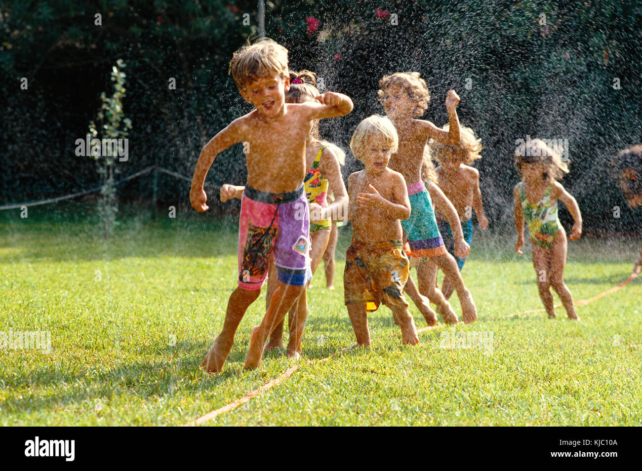 Children Playing in Sprinkler Stock Photo - Alamy
