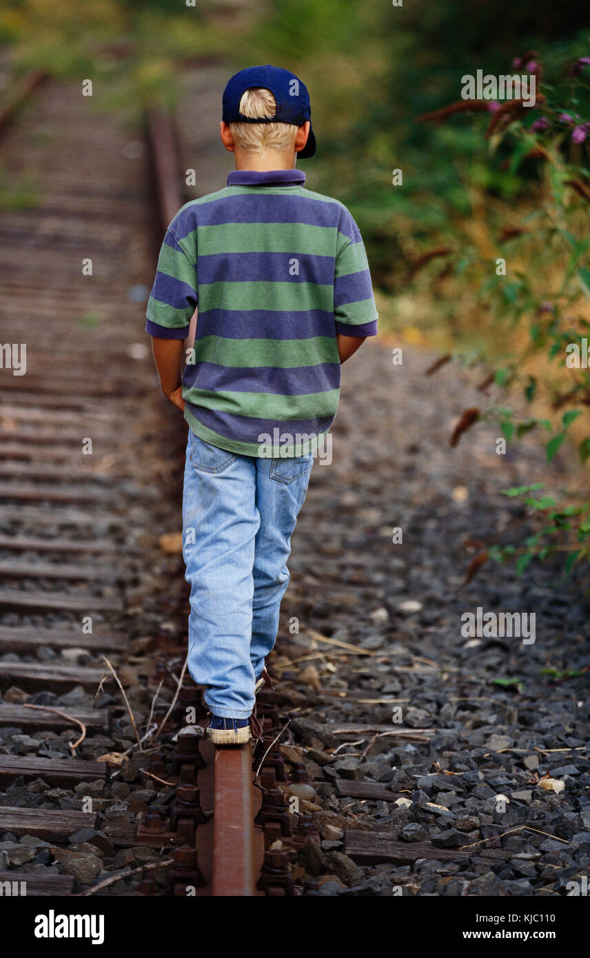 Boy Walking Along Train Tracks Stock Photo - Alamy