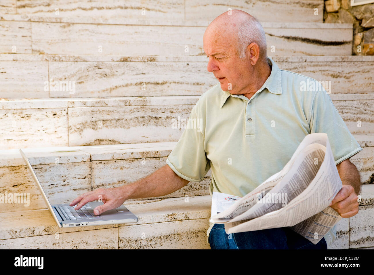 Man Reading Newspaper and Using Laptop Computer Stock Photo - Alamy