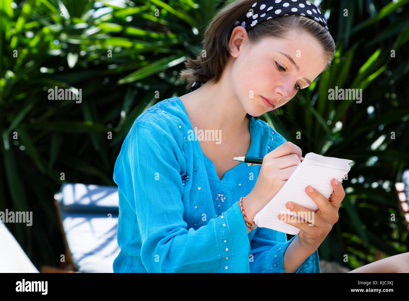 Girl Writing in Notebook Stock Photo - Alamy
