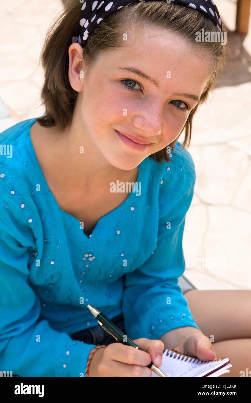 Girl Writing in Notebook Stock Photo - Alamy