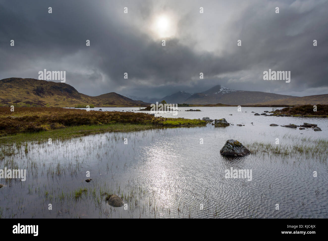 Moor landscape with a river and the sun glowing through dense cloudy ...