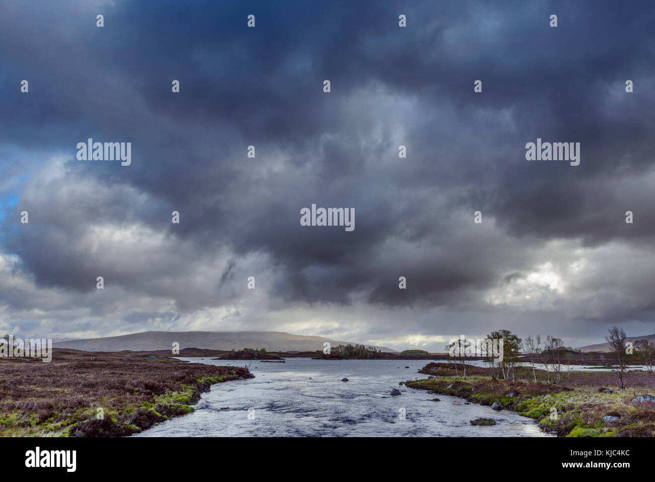 River in moor landscape with dark storm clouds at Rannoch Moor in ...