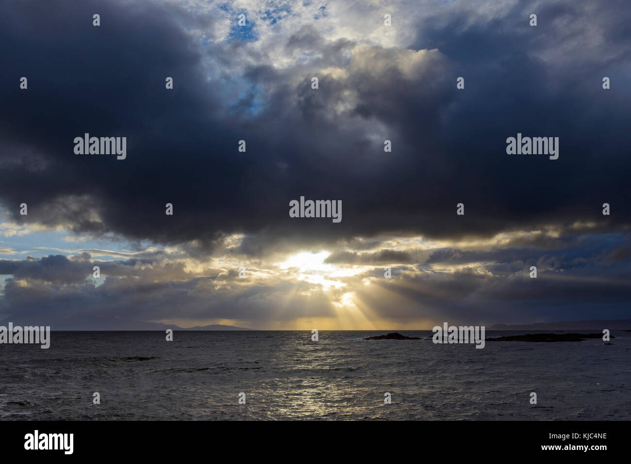 Sun shining through the storm clouds at sunrise along the Scottish ...