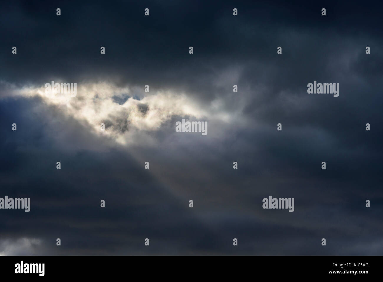 Sun breaking through dark storm clouds at Bamburgh in Northumberland ...