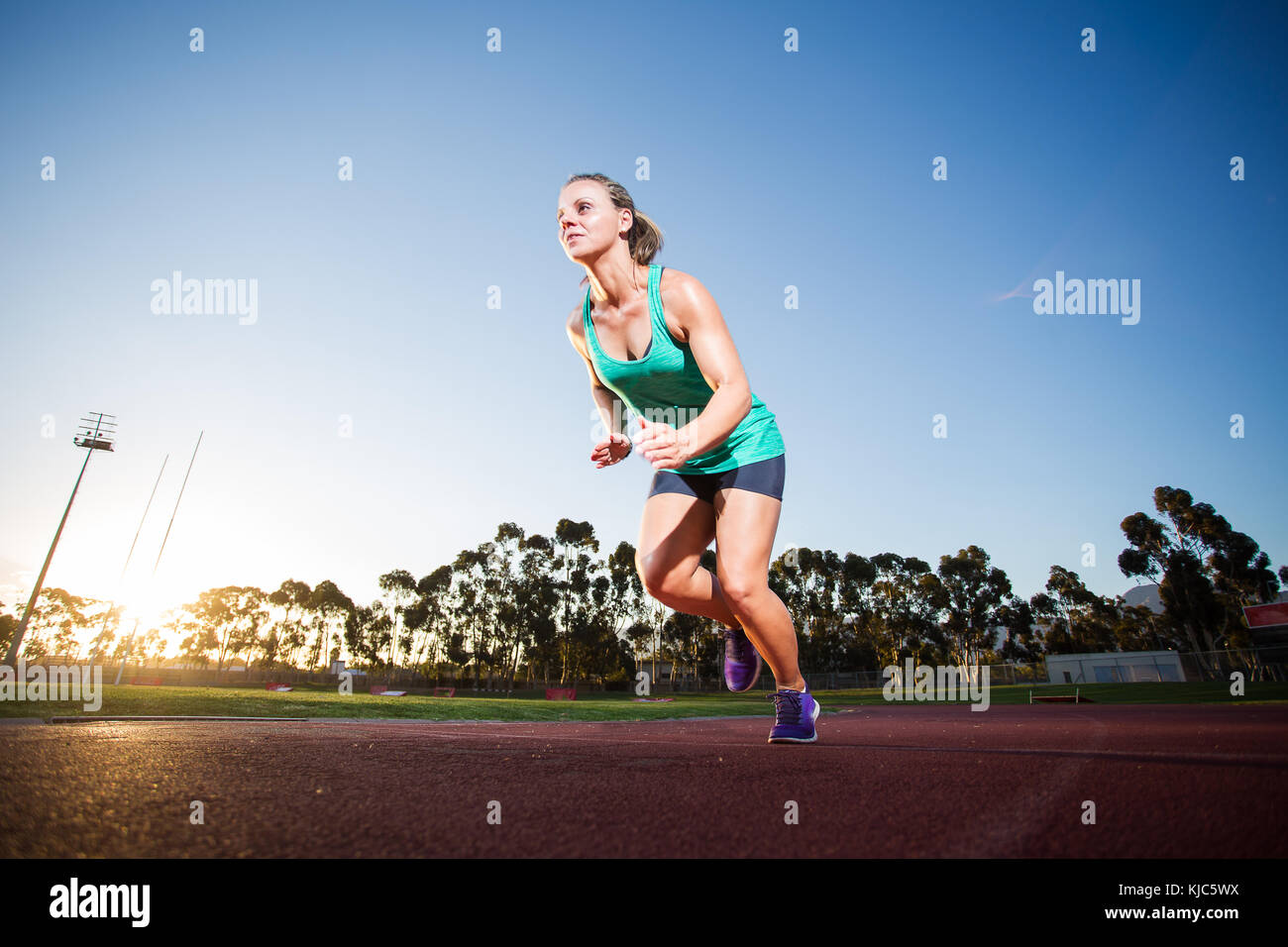 Close up wide angle view of a female sprinter athlete getting ready to ... Close up wide angle view of a female sprinter athlete getting ready to ...