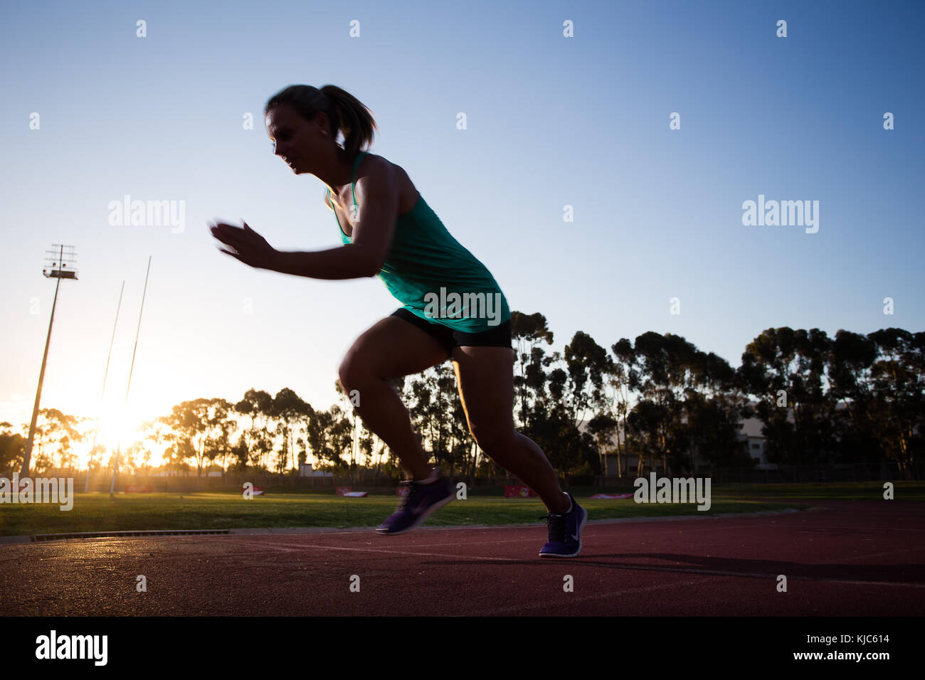 Close up wide angle view of a female sprinter athlete getting ready to ...