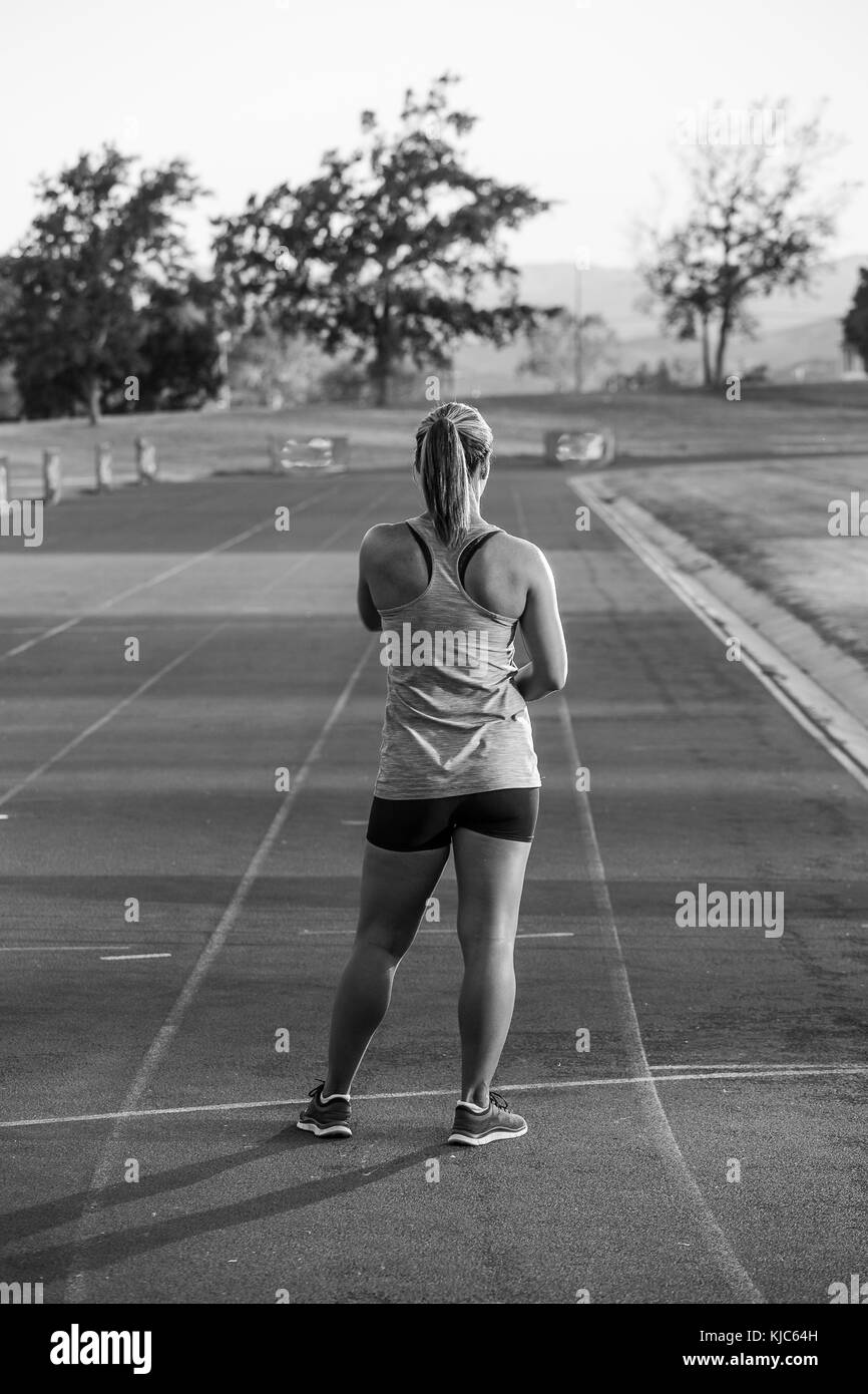 Close up wide angle view of a female sprinter athlete getting ready to ...
