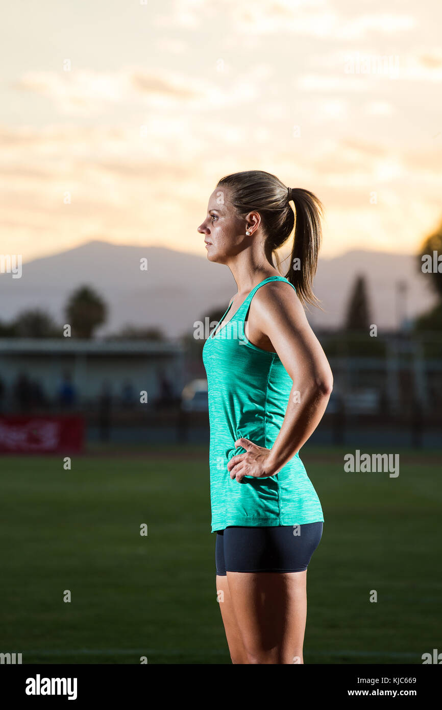 Close up wide angle view of a female sprinter athlete getting ready to ...