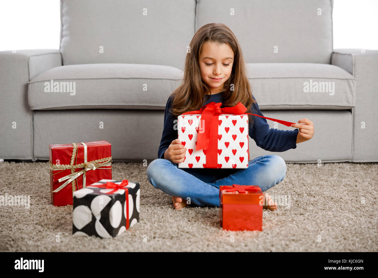 Happy little girl at home opening Christmas presents Stock Photo - Alamy
