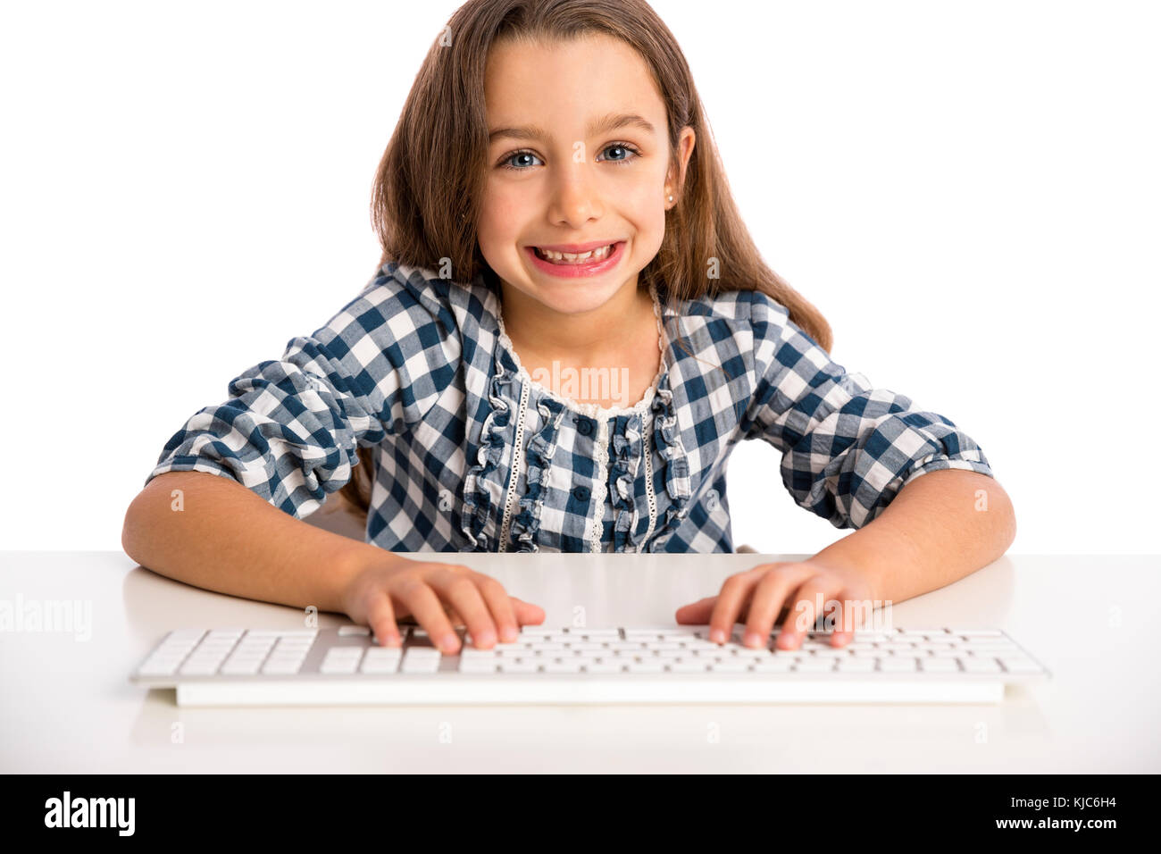 Little girl sitting on a desk and working with a computer Stock Photo ...