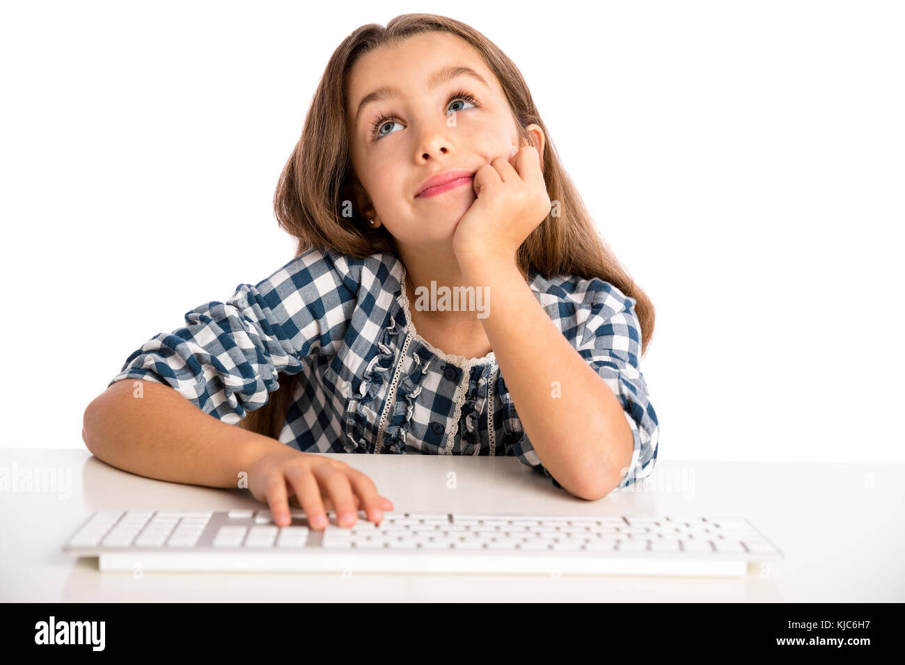 Little girl sitting on a desk and working with a computer Stock Photo ...