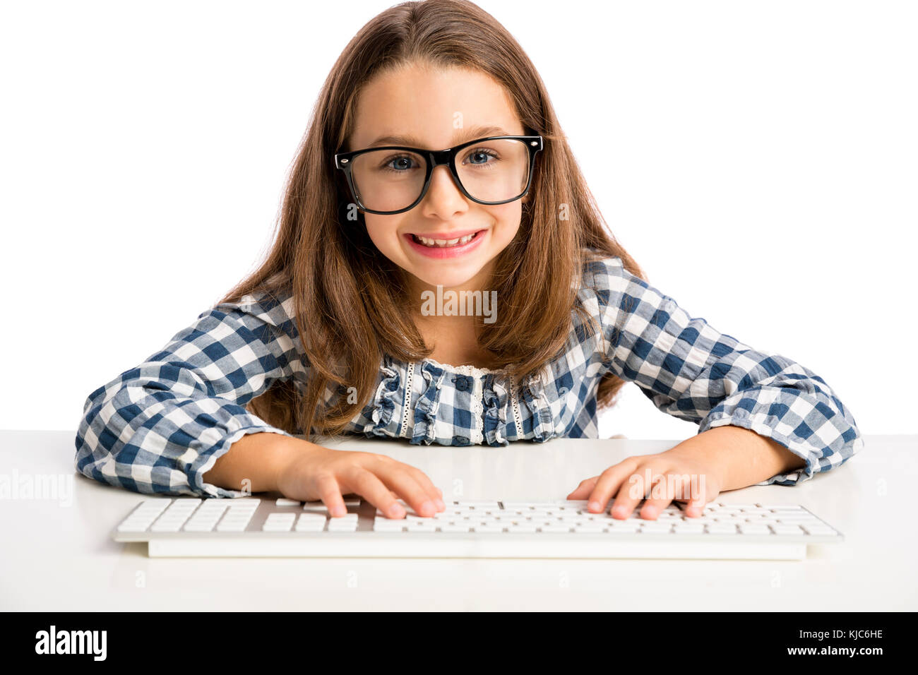 Little girl sitting on a desk and working with a computer Stock Photo ...