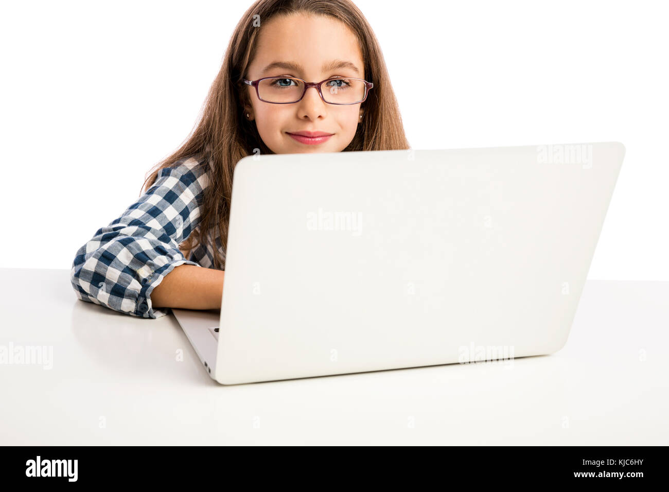 Little girl sitting on a desk and working with a laptop Stock Photo - Alamy