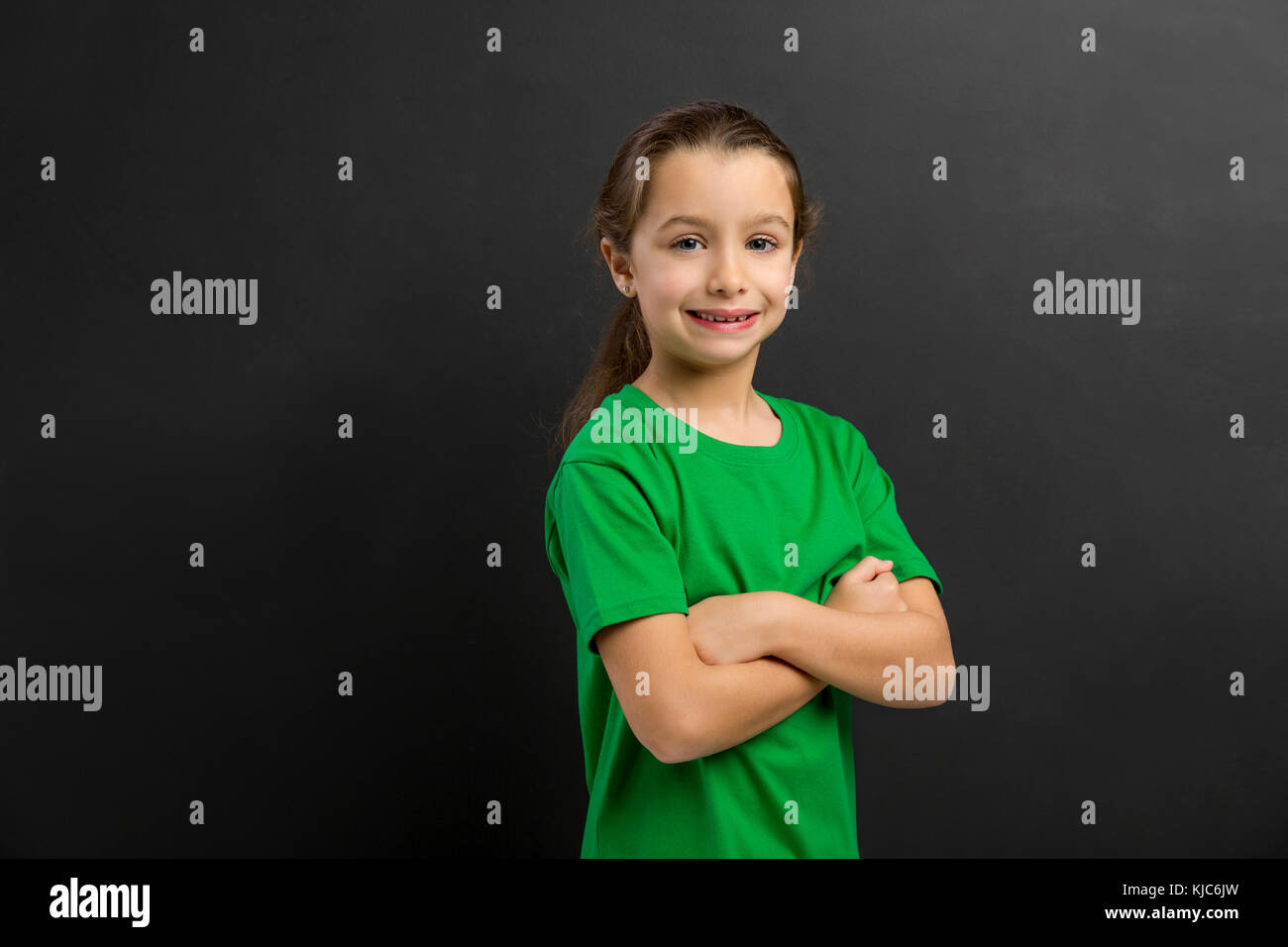 Smart little girl smiling in front of a blackboard Stock Photo - Alamy