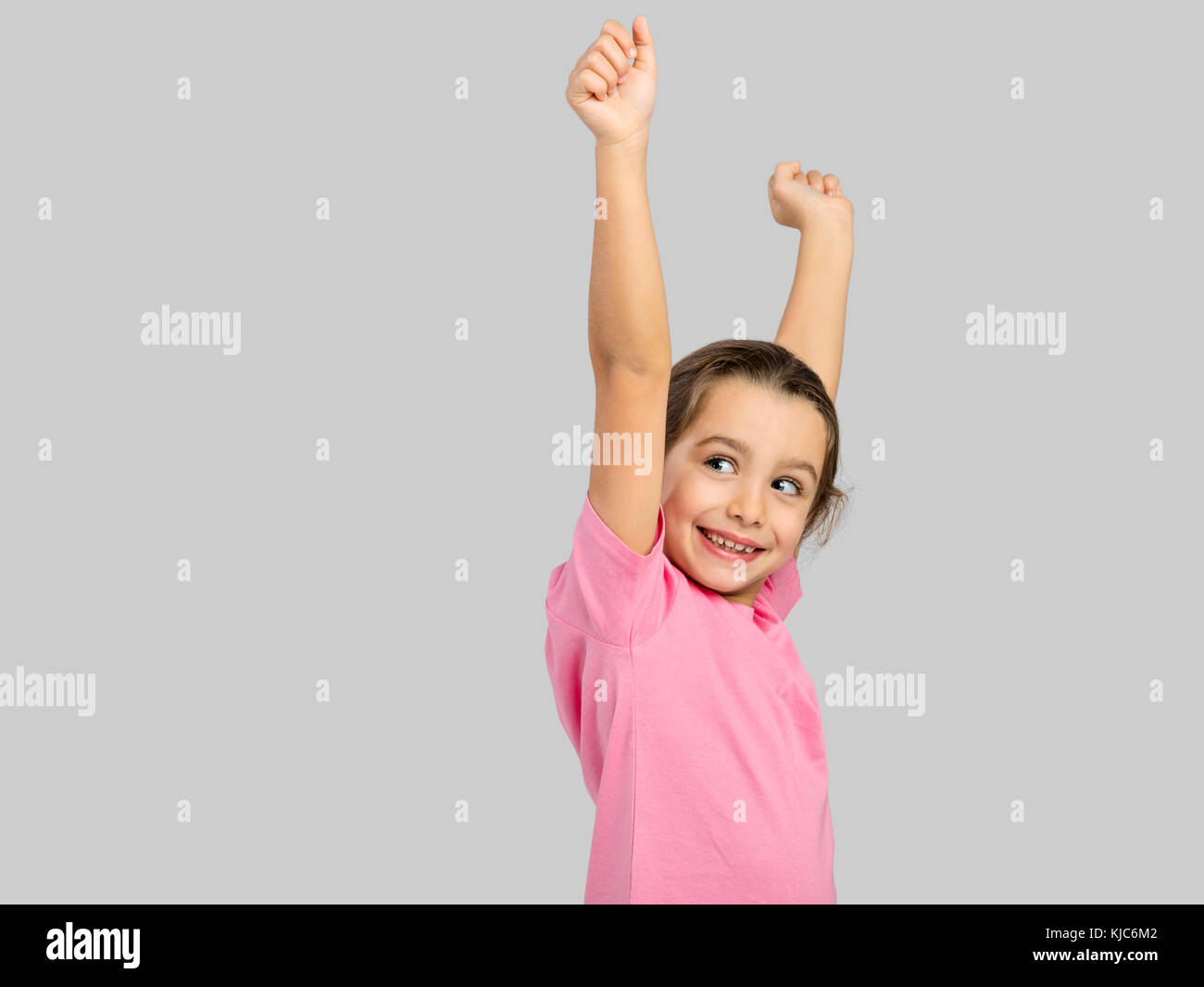 Studio portrait of a happy little girl with arms raised on air Stock ...