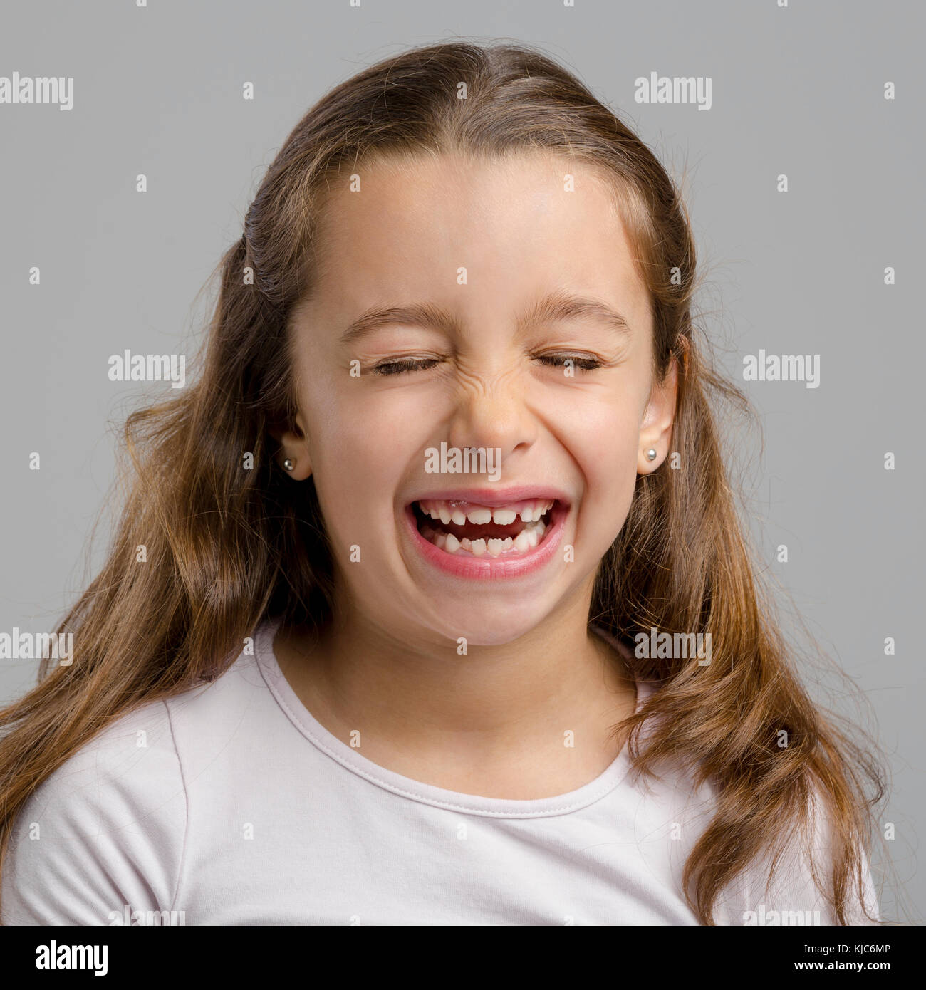 Portrait of a little girl with a laughing expression Stock Photo - Alamy