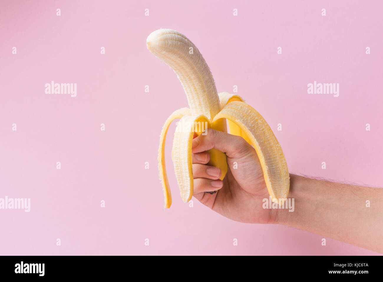 Hands peeling banana isolated on pink background Stock Photo - Alamy