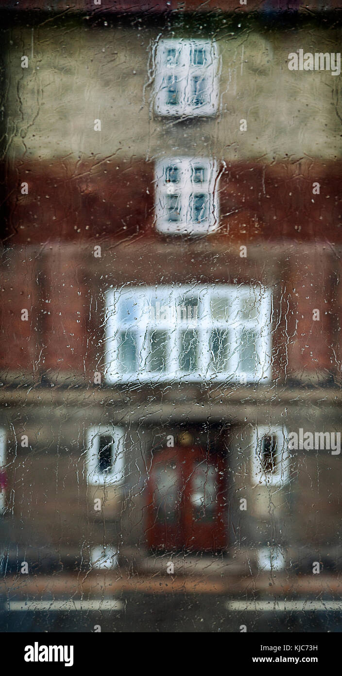 Facade of European Nordic house viewed through a wet windows glass ...