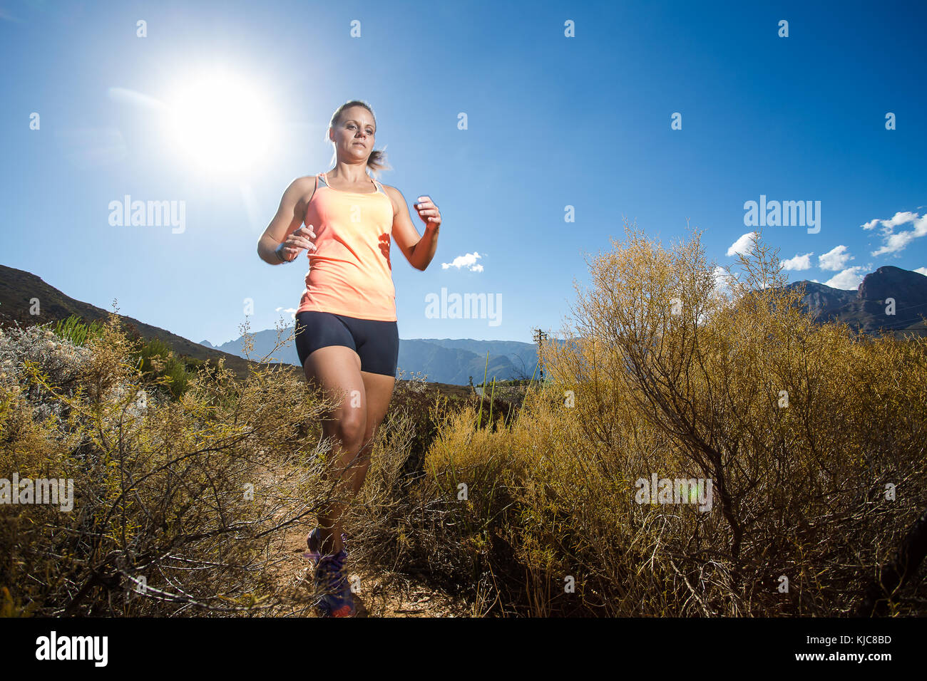 Close up wide angle view of a female sprinter athlete getting ready to ...