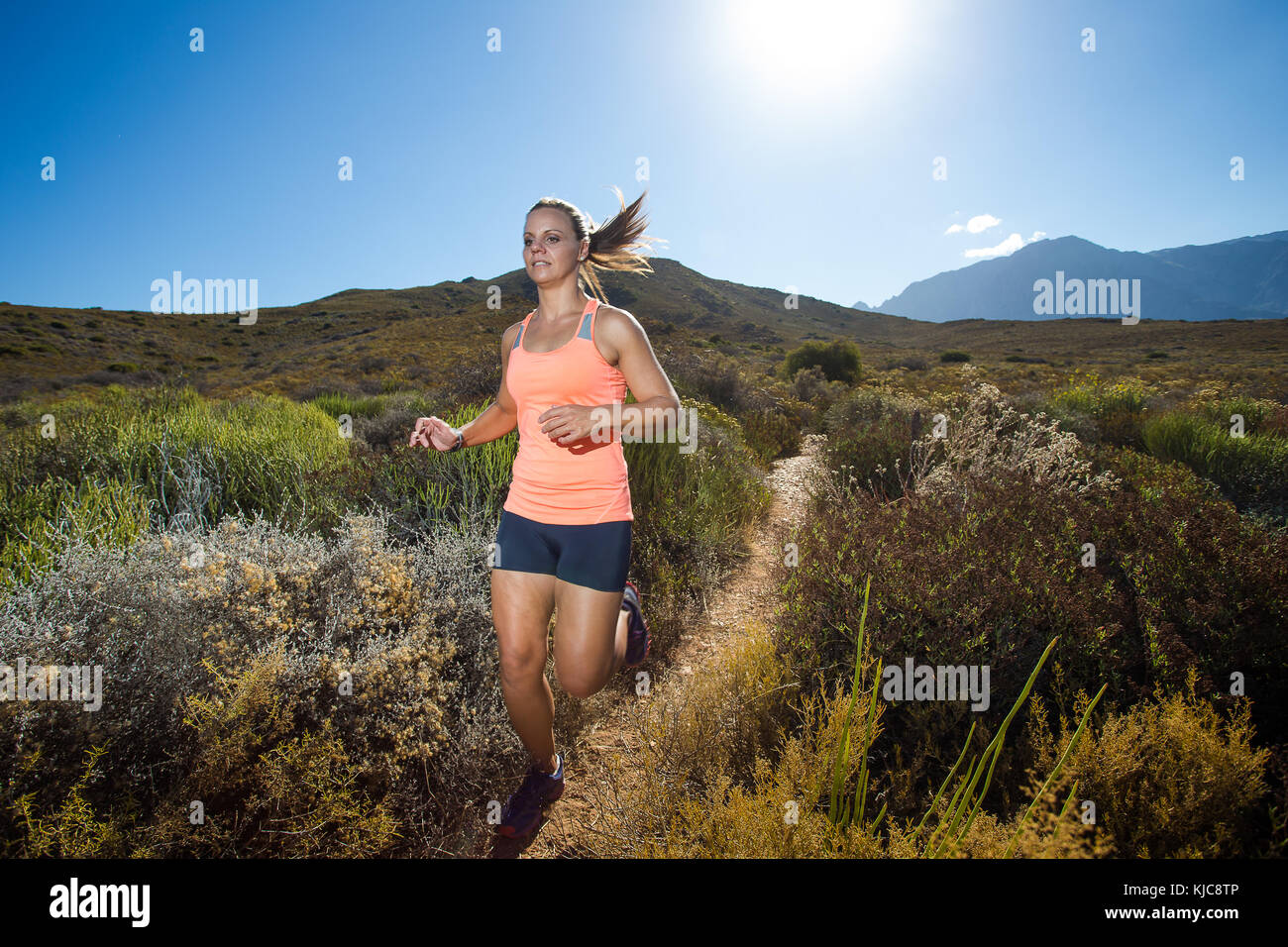 Close up wide angle view of a female sprinter athlete getting ready to ...