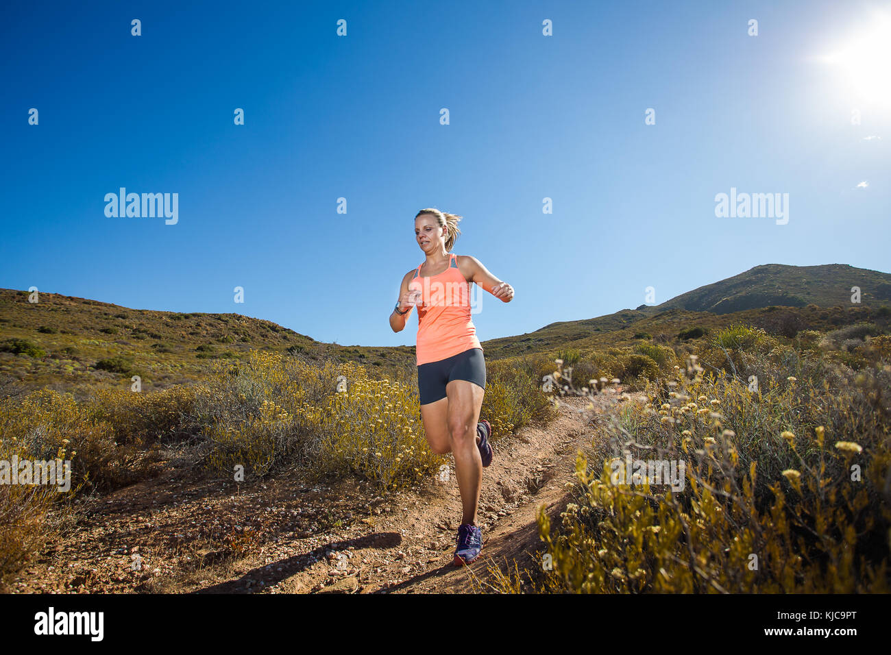 Close up wide angle view of a female sprinter athlete getting ready to ...