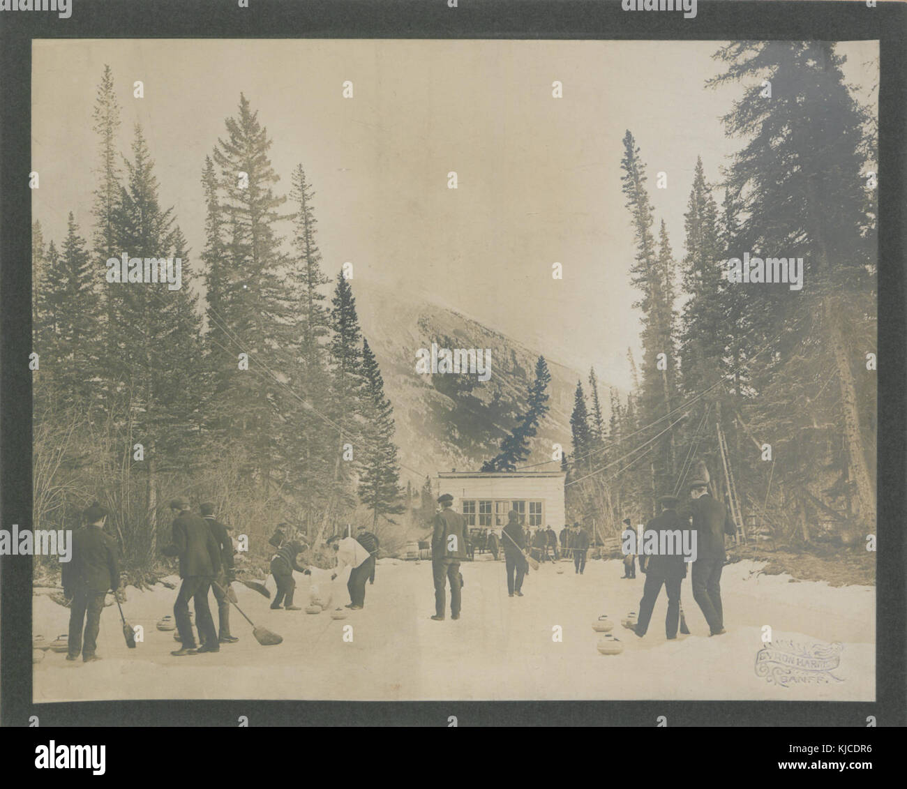 The image depicts a curling match at Banff, showcasing the winter sport ...