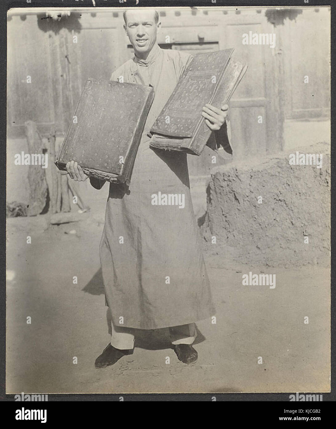 A historical photograph of a man holding the Salar Quran in Kehtsikung ...