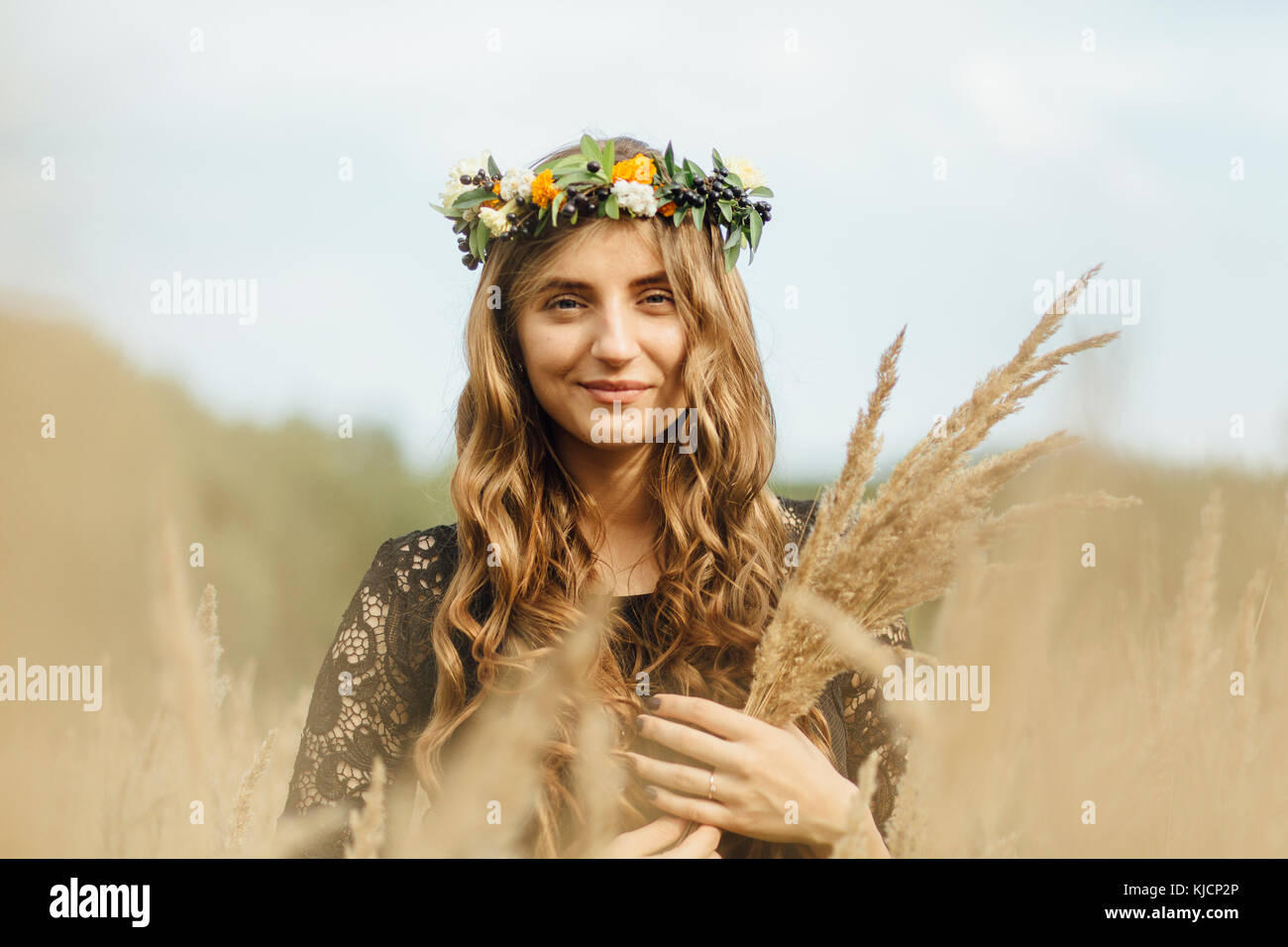 Middle Eastern woman wearing flower crown holding wheat Stock Photo - Alamy