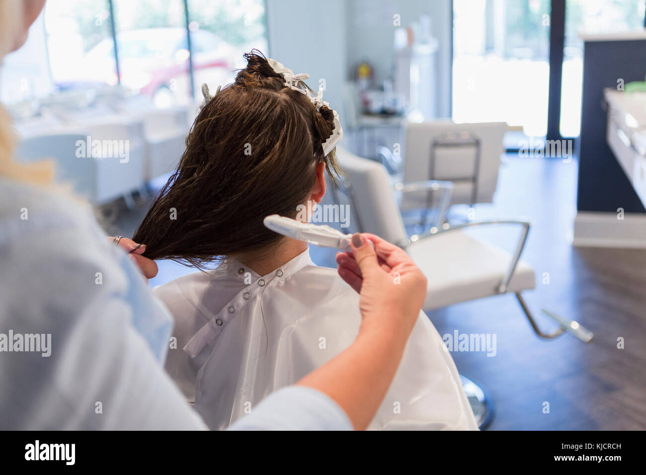 Woman styling hair standing hi-res stock photography and images - Alamy