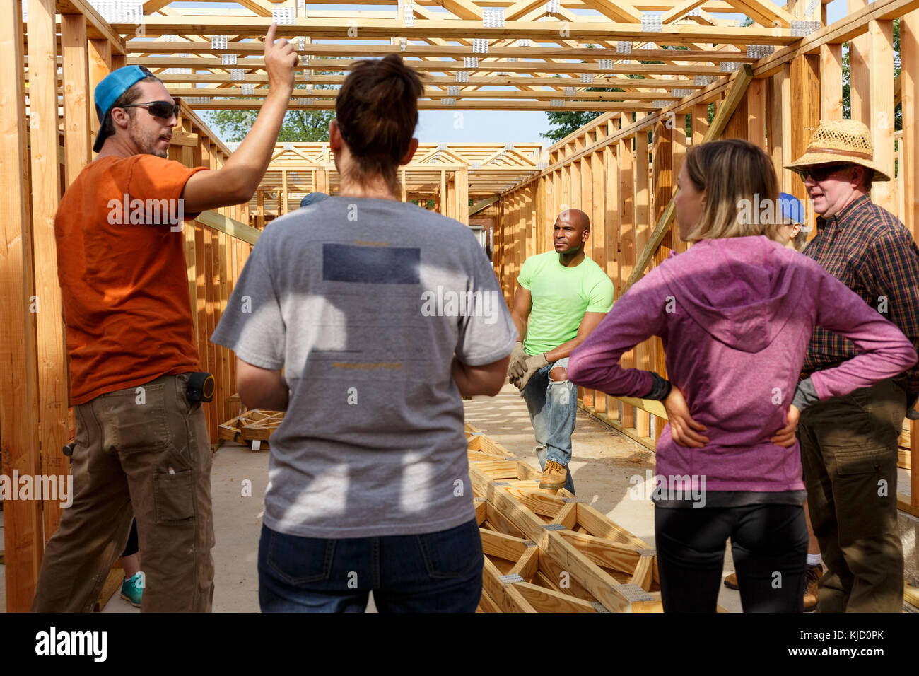 Volunteers talking while building a house Stock Photo - Alamy