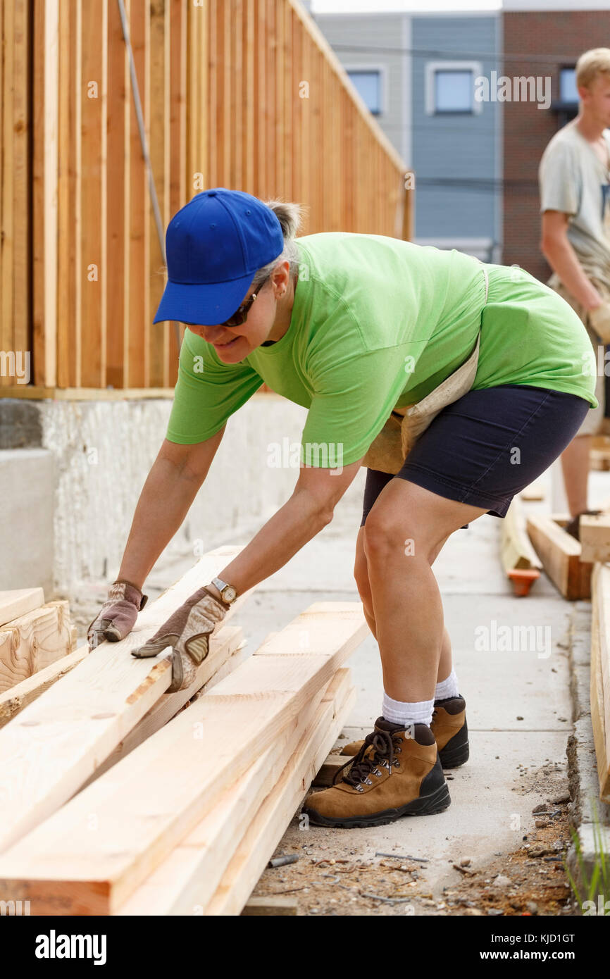 Caucasian woman lifting lumber at construction site Stock Photo - Alamy