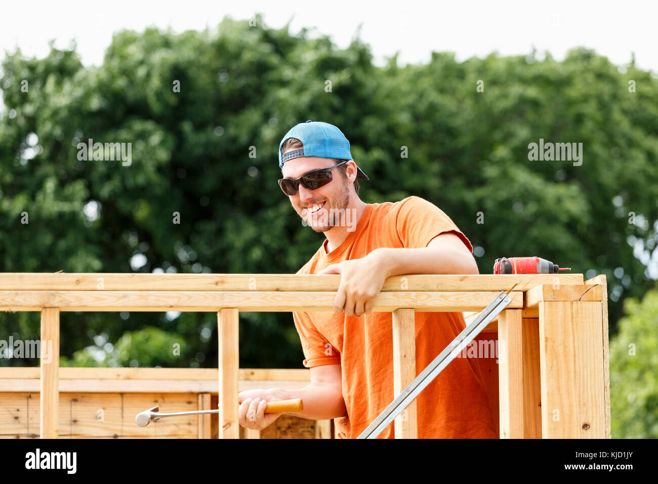 Caucasian man hammering at construction site Stock Photo - Alamy