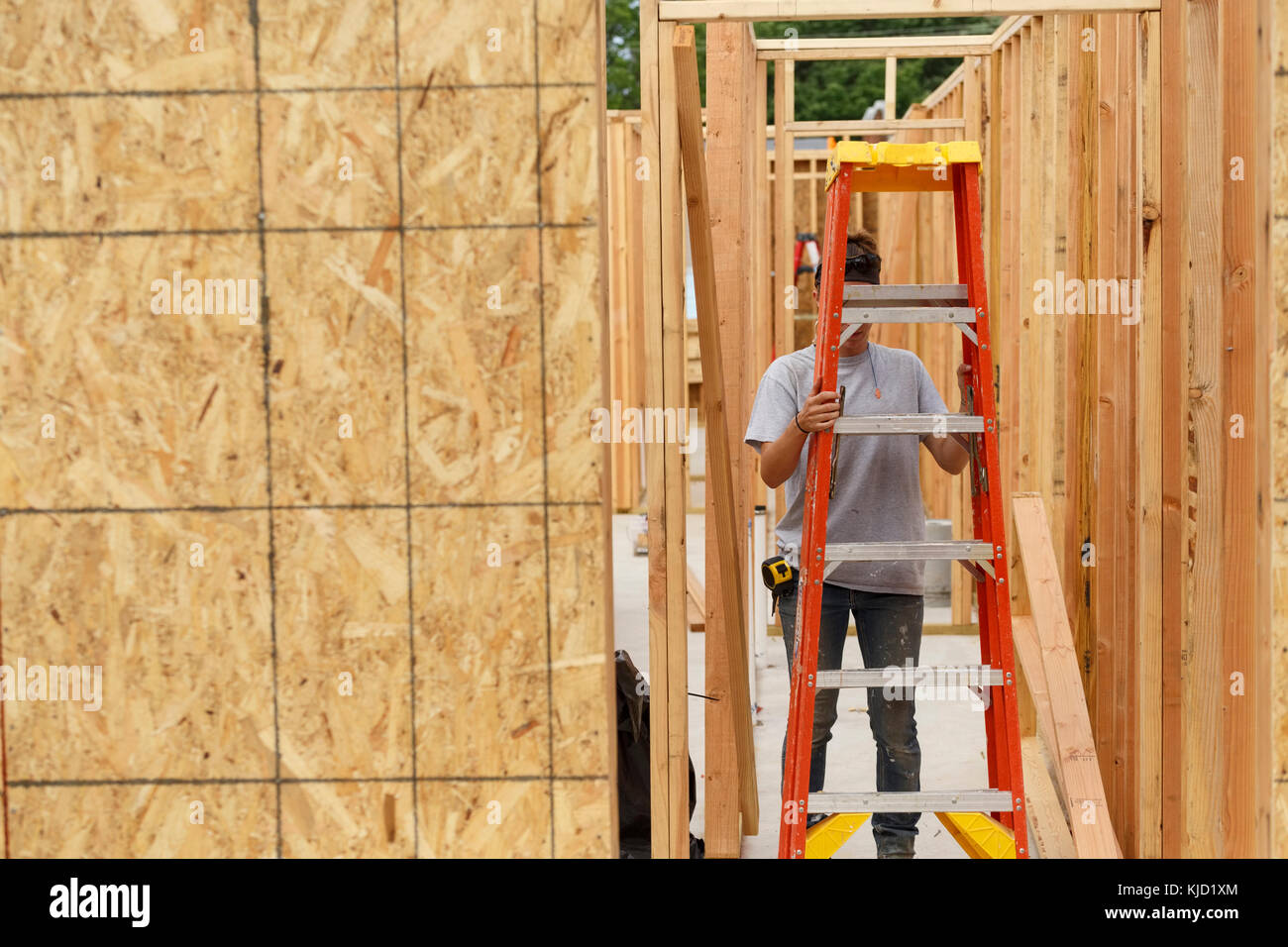 Caucasian woman carrying ladder at construction site Stock Photo - Alamy