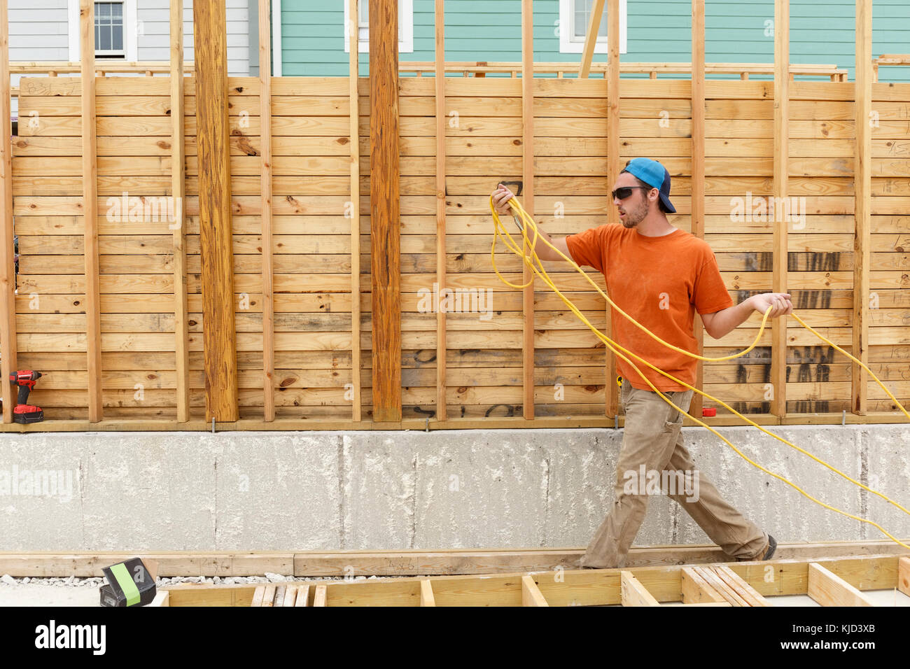 Caucasian man carrying wire at construction site Stock Photo - Alamy
