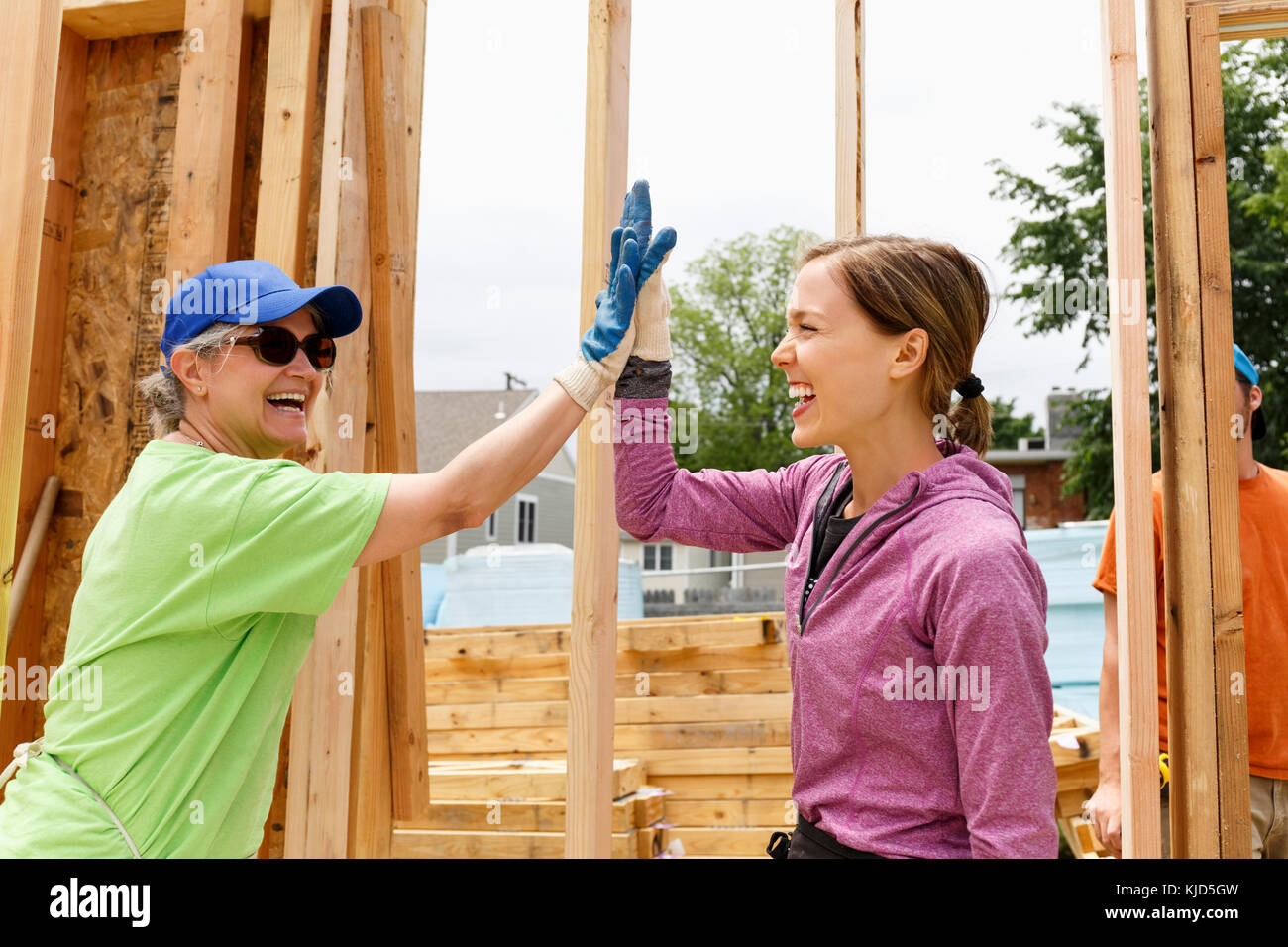 Caucasian volunteers high-fiving at construction site Stock Photo - Alamy