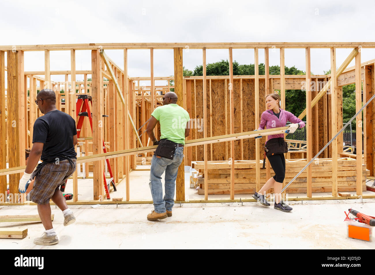Volunteers carrying lumber at construction site Stock Photo - Alamy