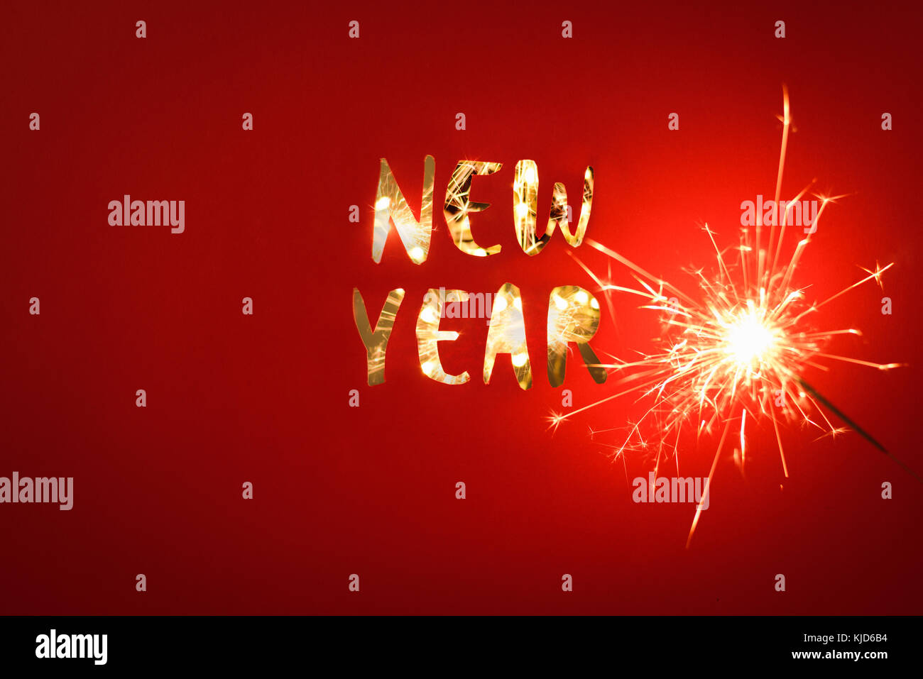 Word NEW YEAR with lights and sparkles on red background Stock Photo ...